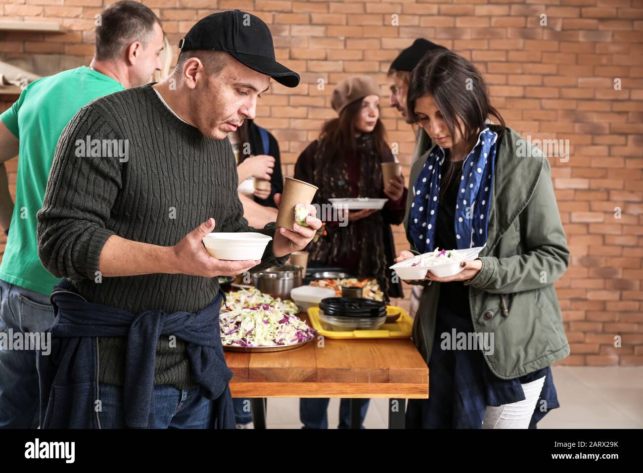 Volunteers giving food to homeless people Stock Photo - Alamy
