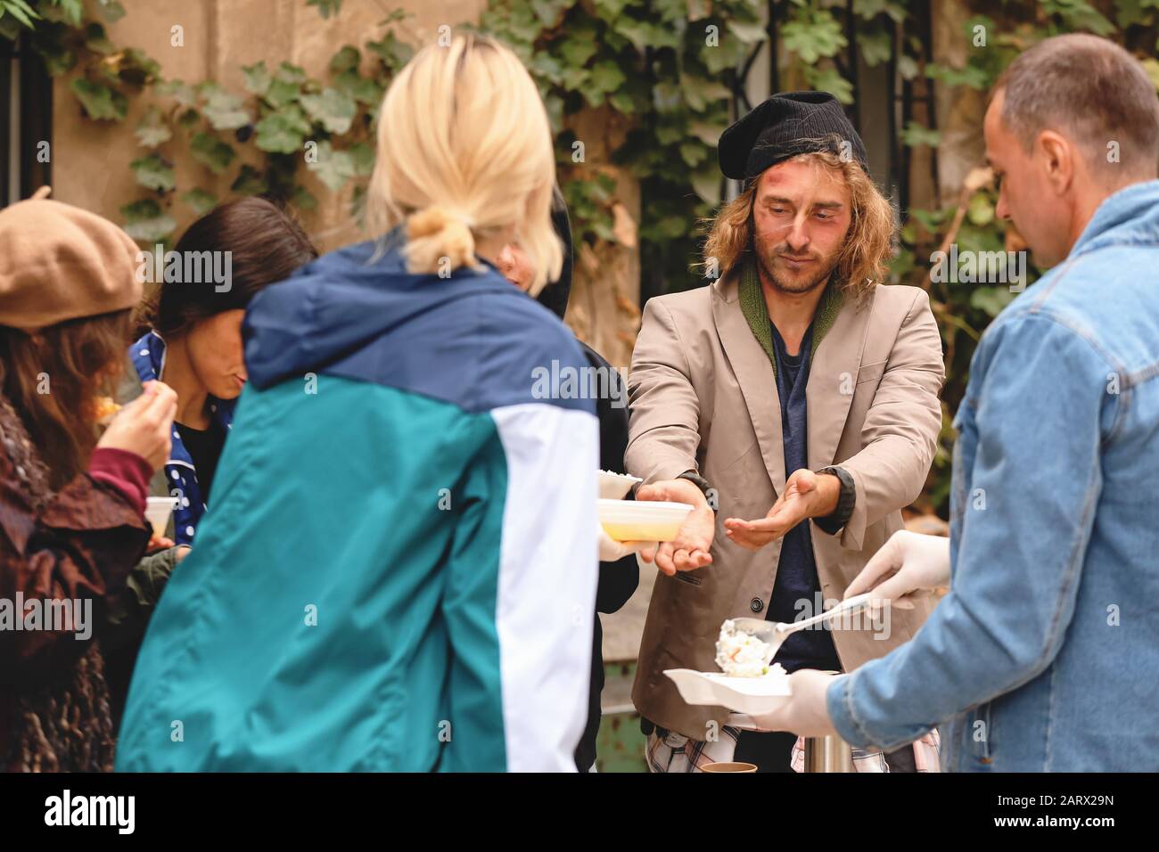 Volunteers giving food to homeless people outdoors Stock Photo - Alamy