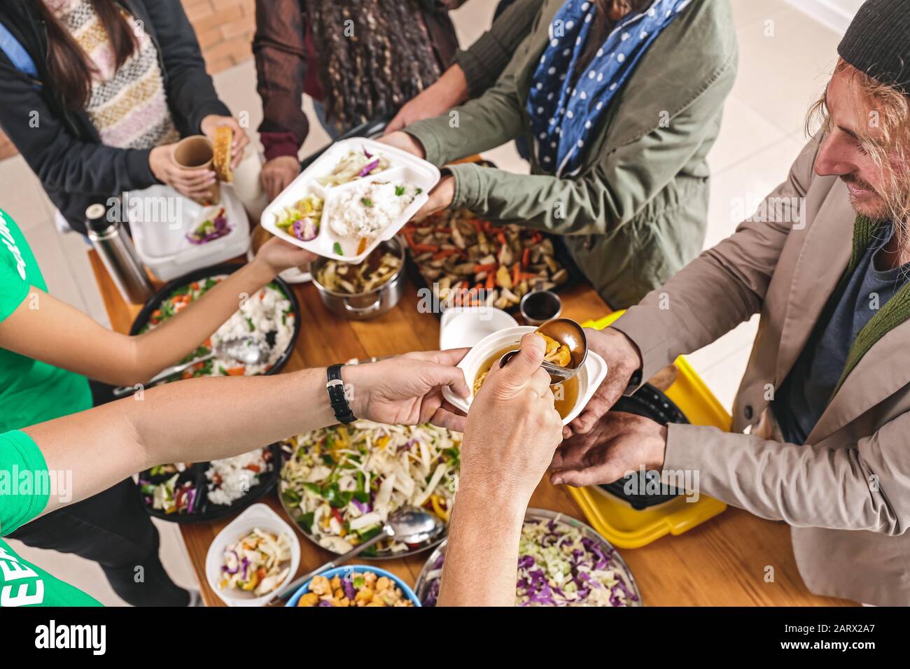 Volunteers giving food to homeless people, top view Stock Photo - Alamy