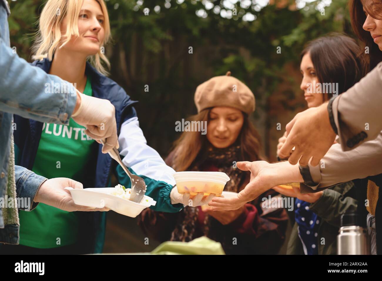 Volunteers giving food to homeless people outdoors Stock Photo - Alamy