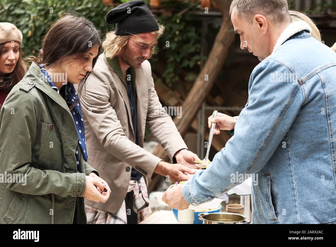 Volunteers giving food to homeless people outdoors Stock Photo - Alamy