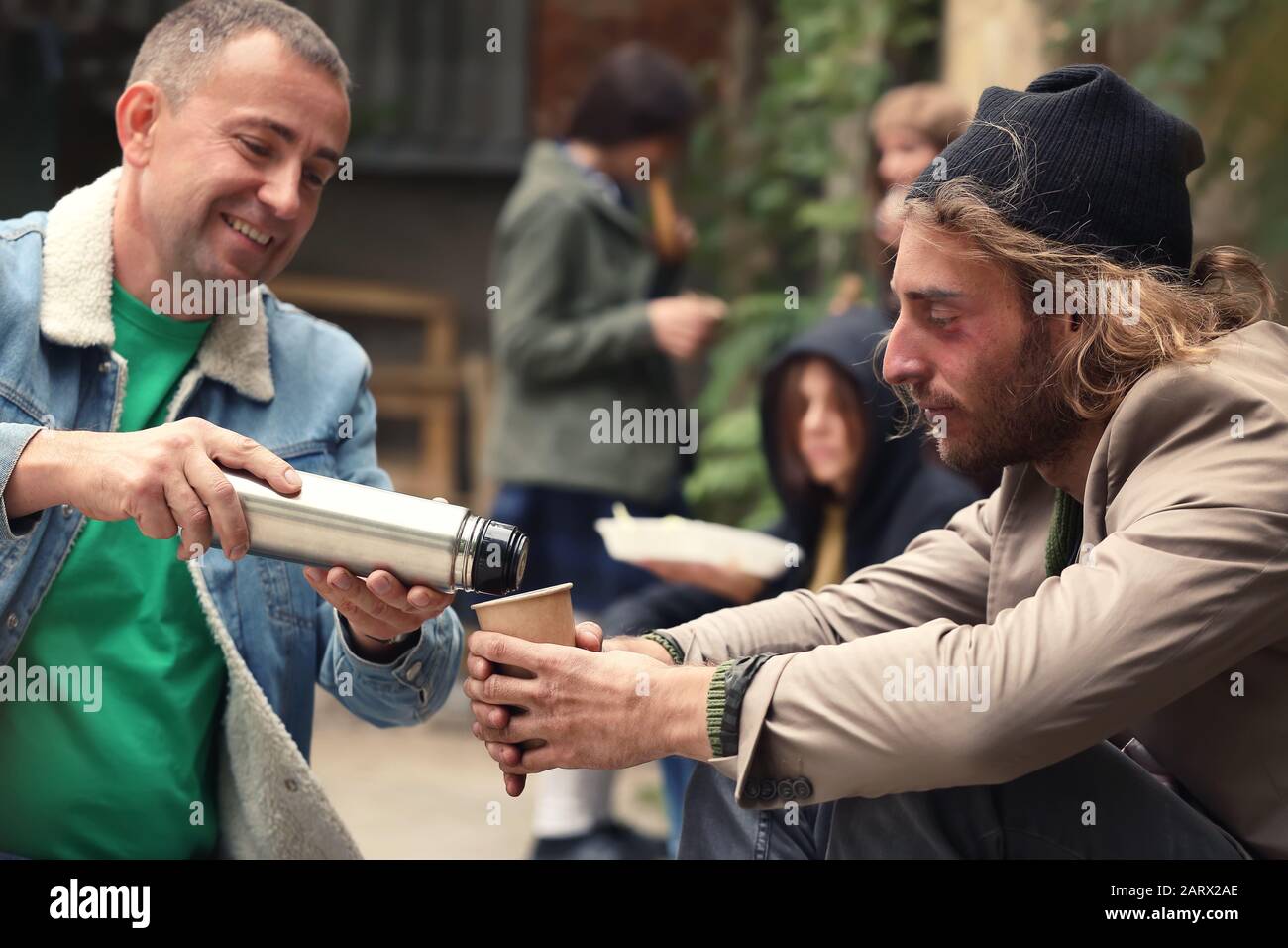 Giving drink homeless hi-res stock photography and images - Alamy