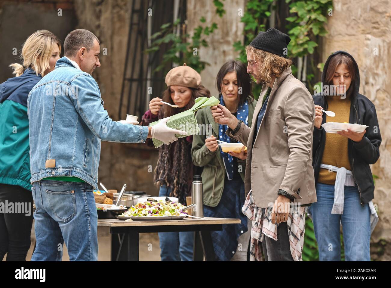 Volunteers giving food to homeless people outdoors Stock Photo - Alamy
