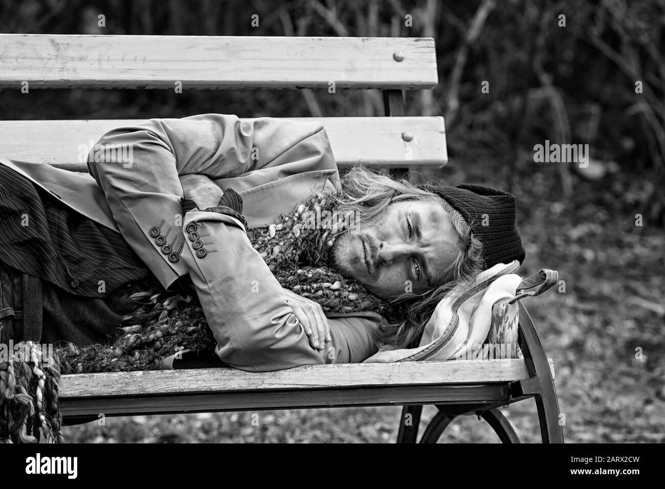 Black and white portrait of poor homeless man sleeping on bench ...