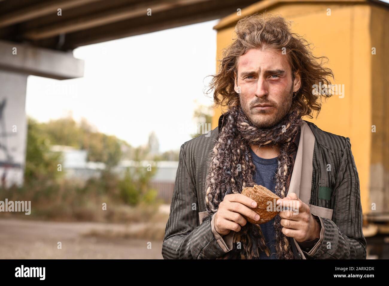 Portrait of poor homeless man with piece of bread outdoors Stock Photo ...