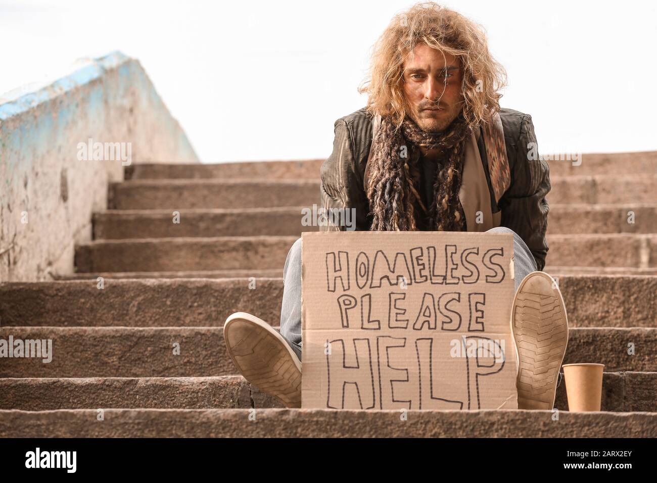 Portrait of poor homeless man sitting on stairs outdoors Stock Photo ...