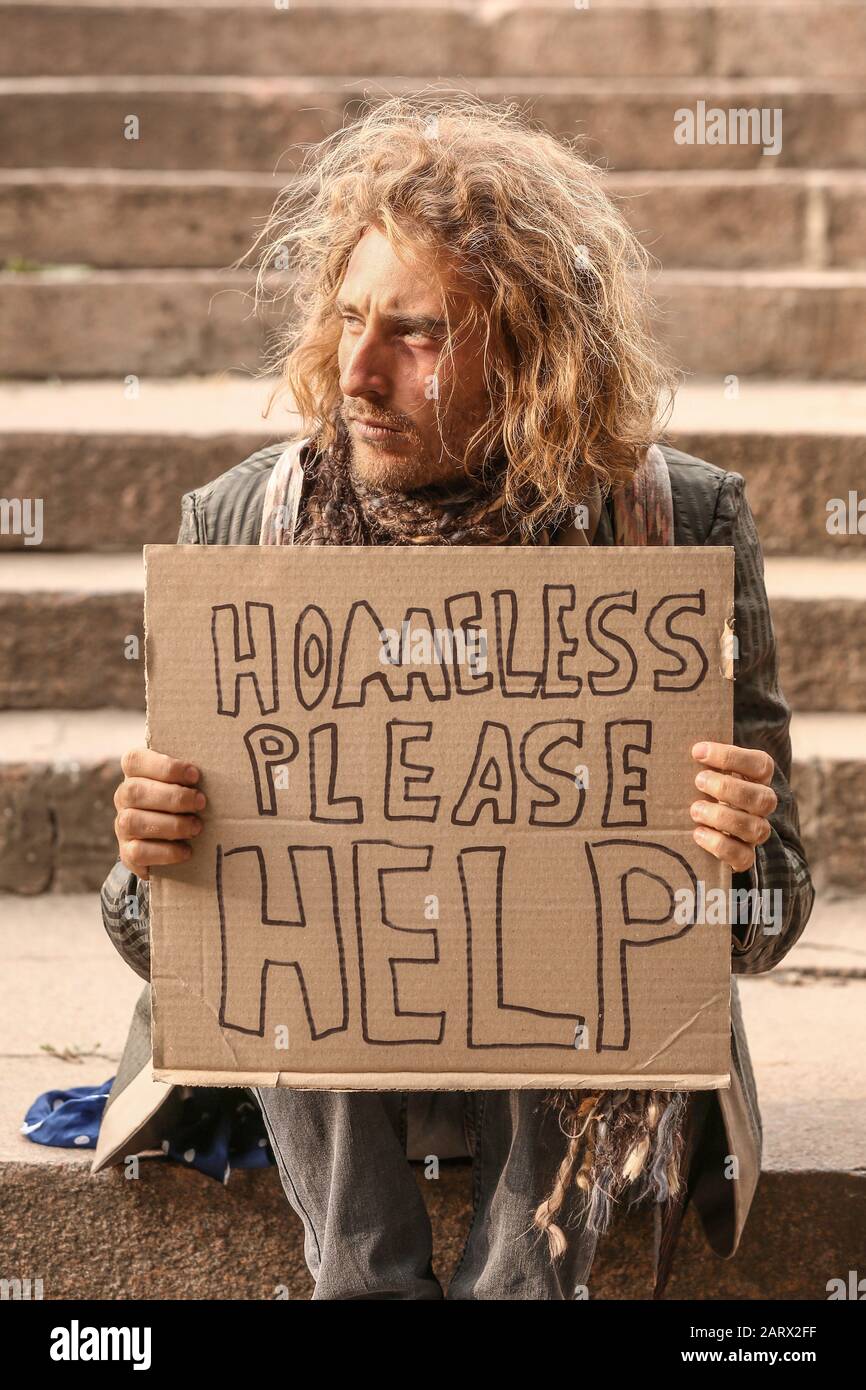 Portrait of poor homeless man sitting on stairs outdoors Stock Photo ...