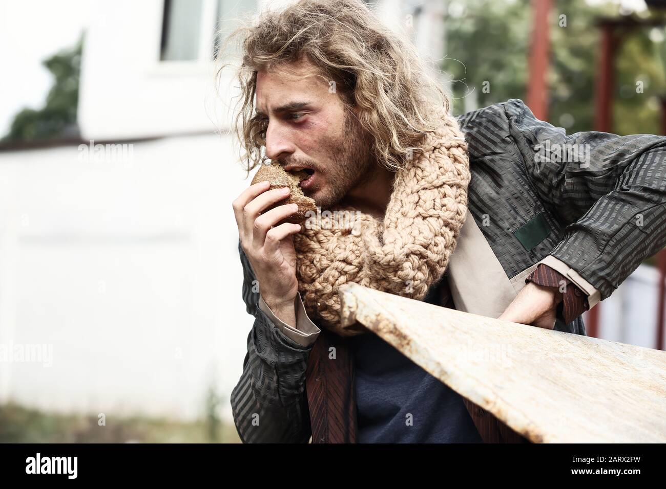 Poor homeless man looking for food in garbage toter outdoors Stock ...