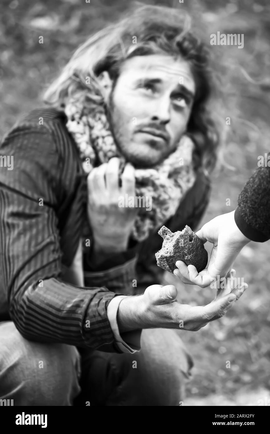 Woman giving bread to poor homeless man outdoors Stock Photo - Alamy