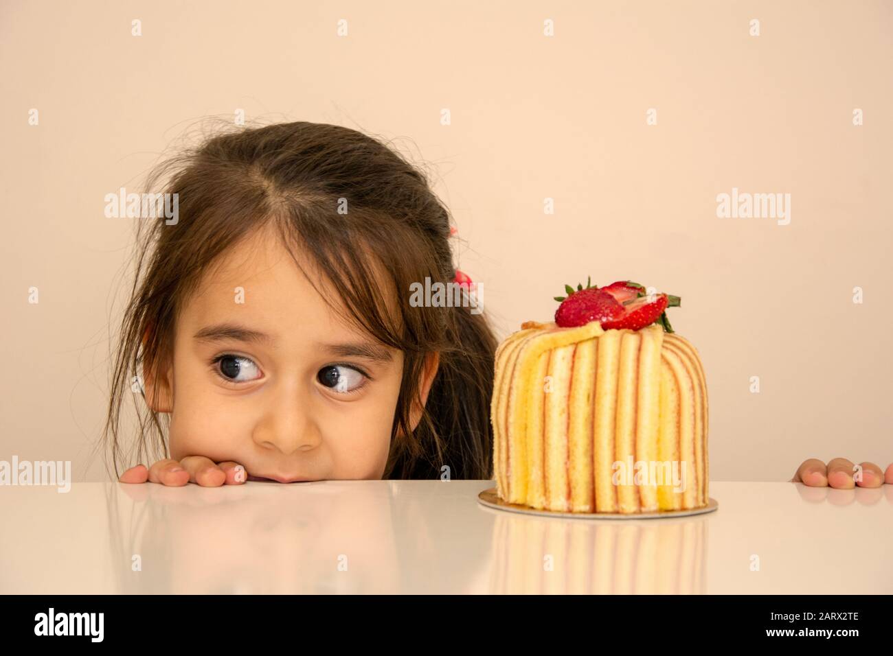 Little girl looking at cake and is surprised Stock Photo - Alamy