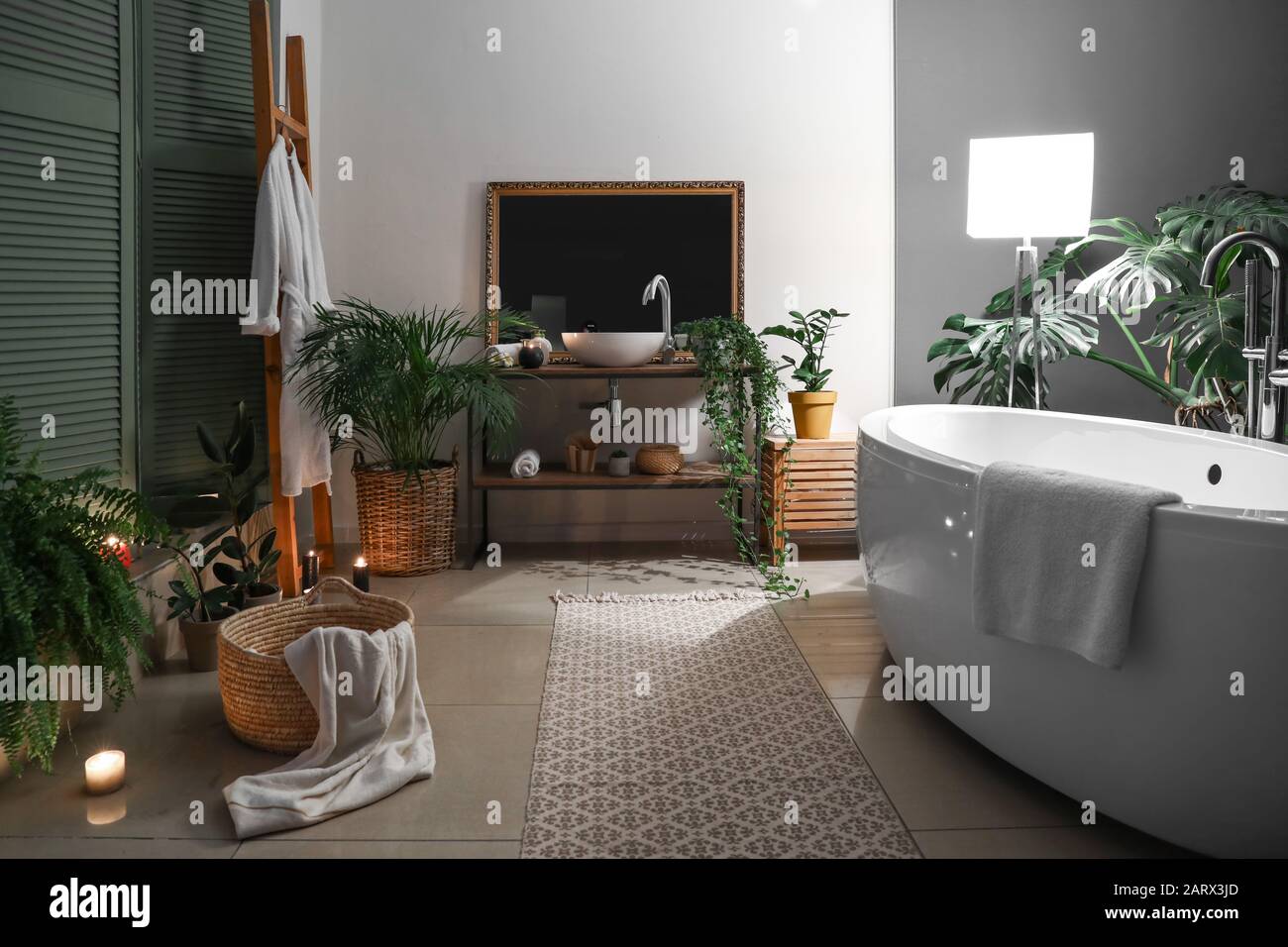 Stylish interior of bathroom at night Stock Photo - Alamy