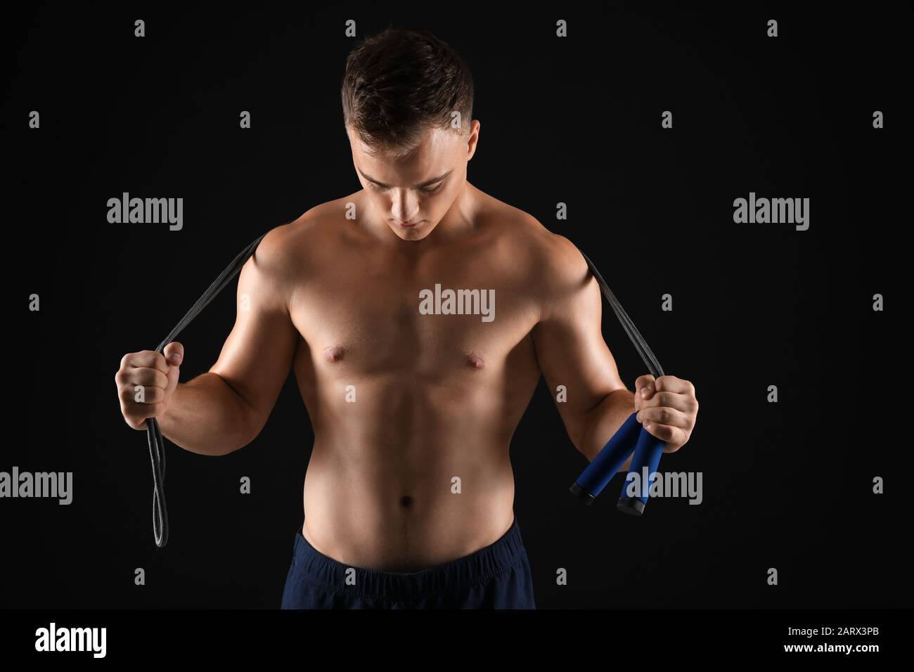Handsome male bodybuilder with jumping rope on dark background Stock ...
