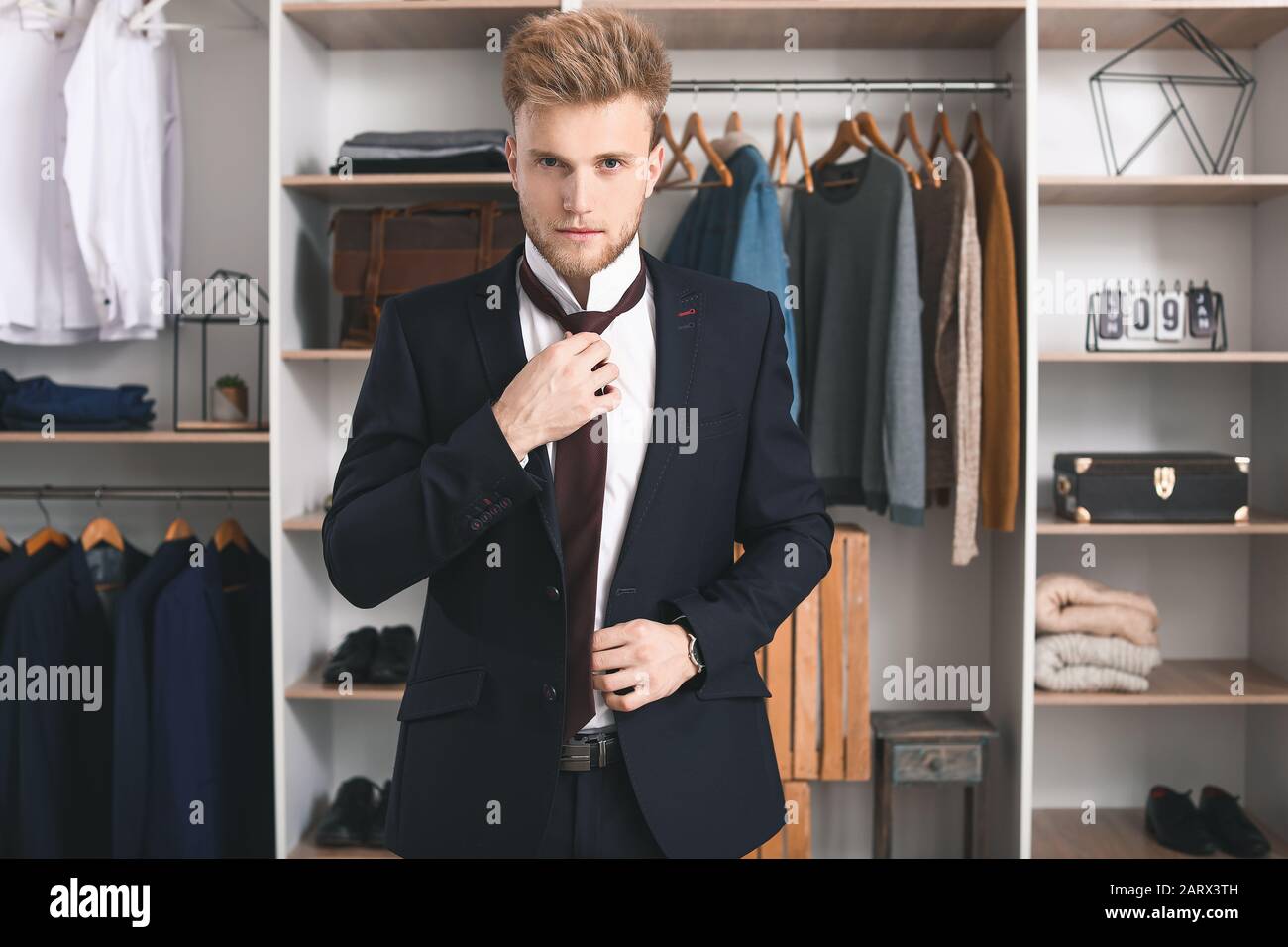 Handsome man wearing necktie in dressing room Stock Photo - Alamy