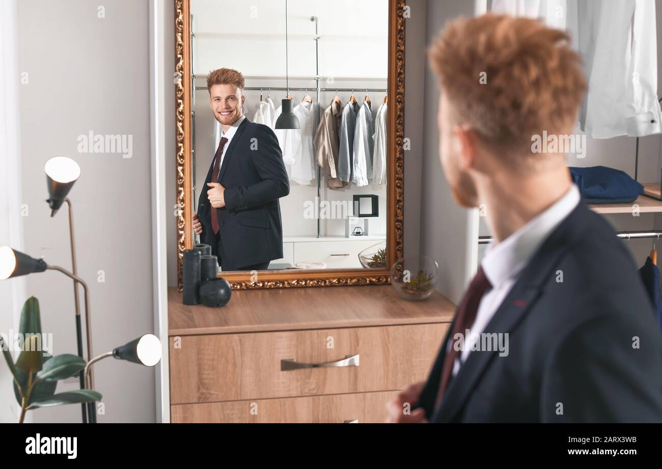 Handsome man trying on stylish clothes in dressing room Stock Photo - Alamy