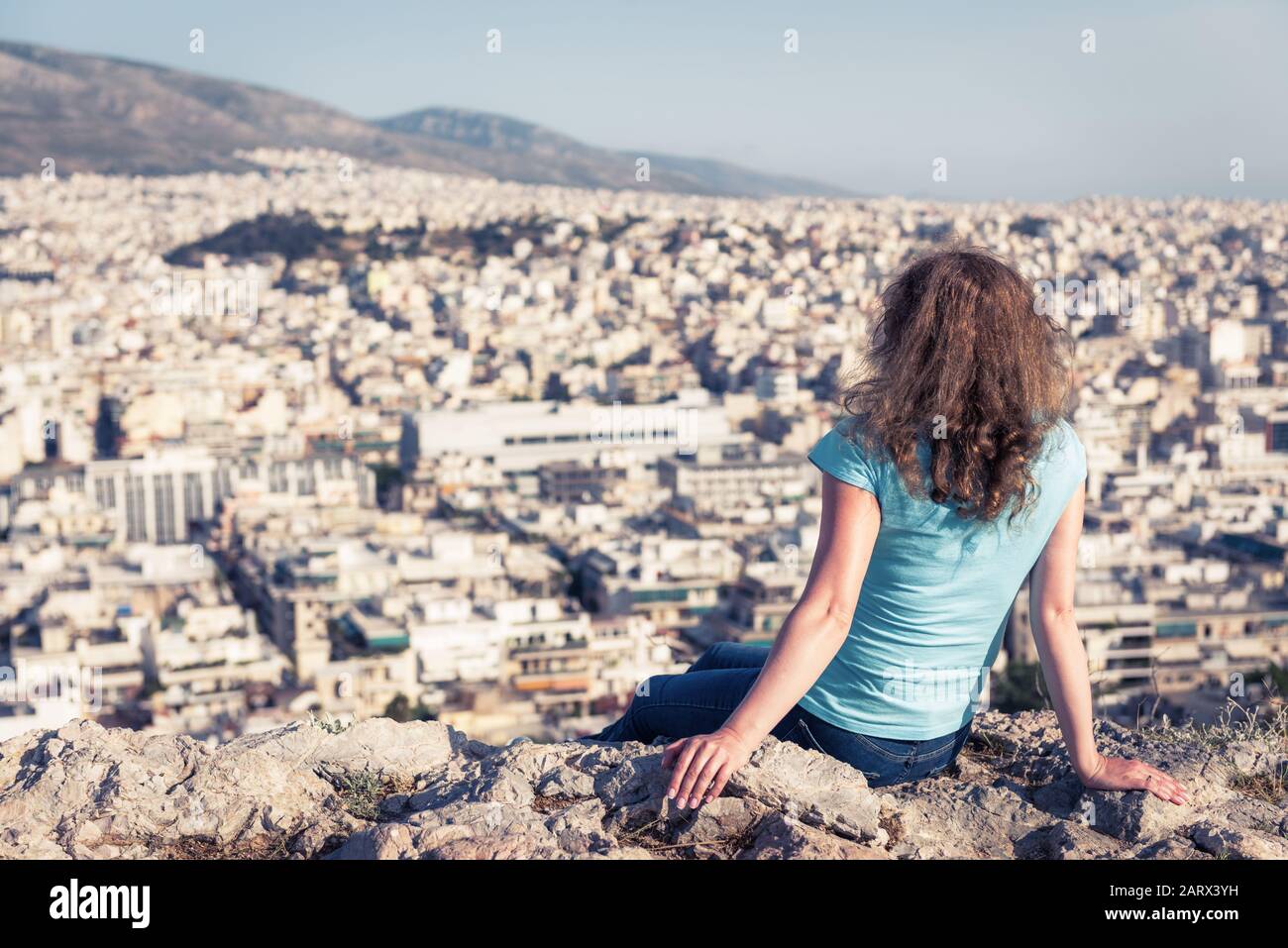 Attractive young woman looks at cityscape Athens, Greece. Adult girl ...