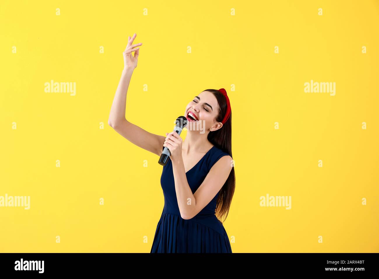 Beautiful young female singer with microphone on color background Stock ...