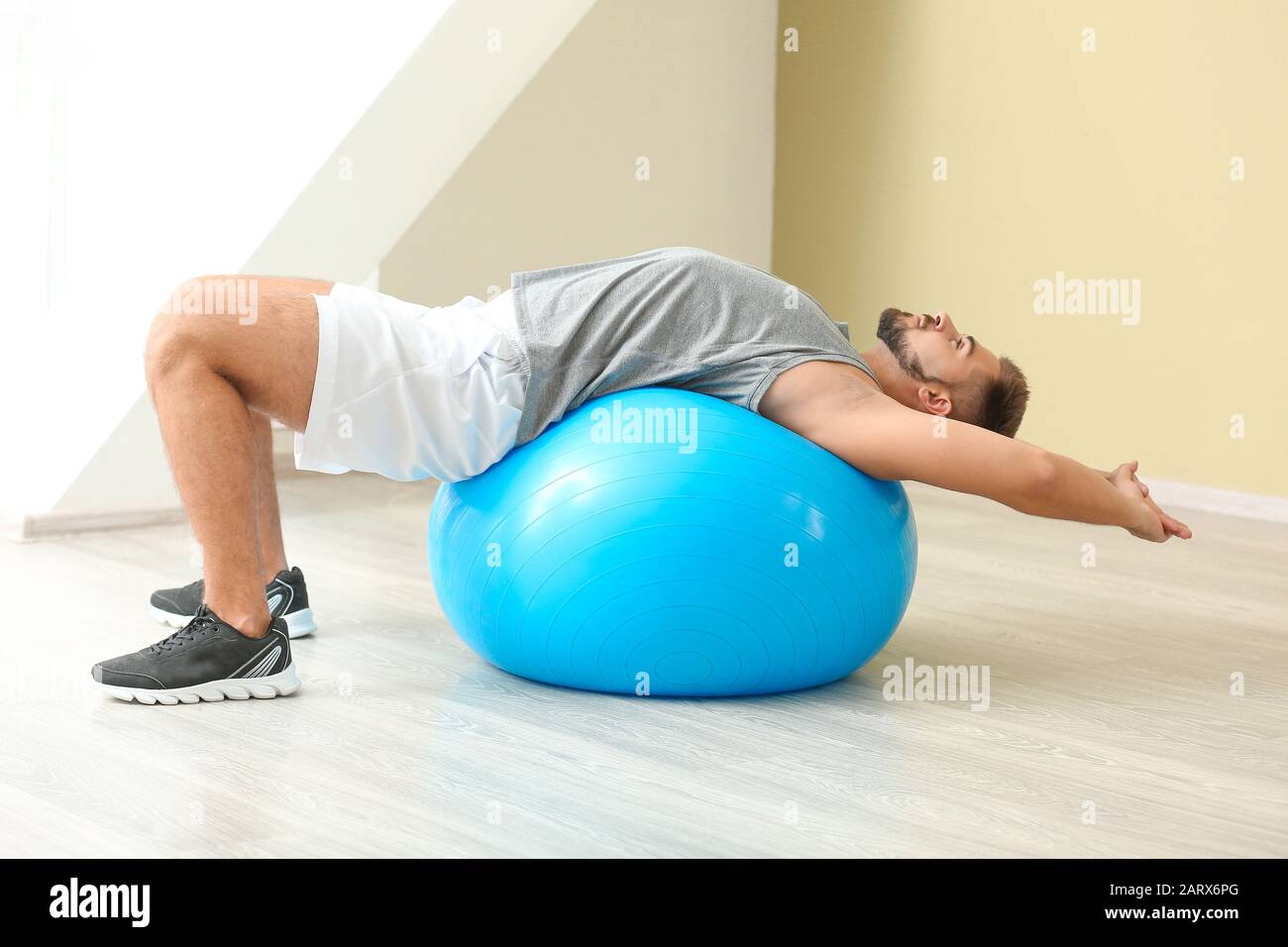 Sporty young man training with fitball in gym Stock Photo - Alamy