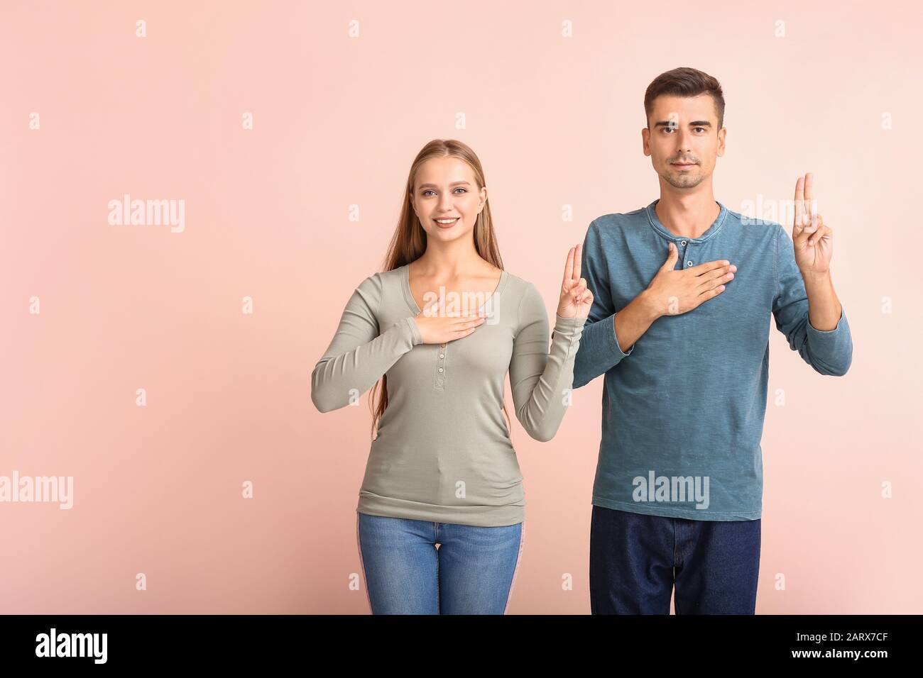 Young deaf mute couple using sign language on color background Stock ...