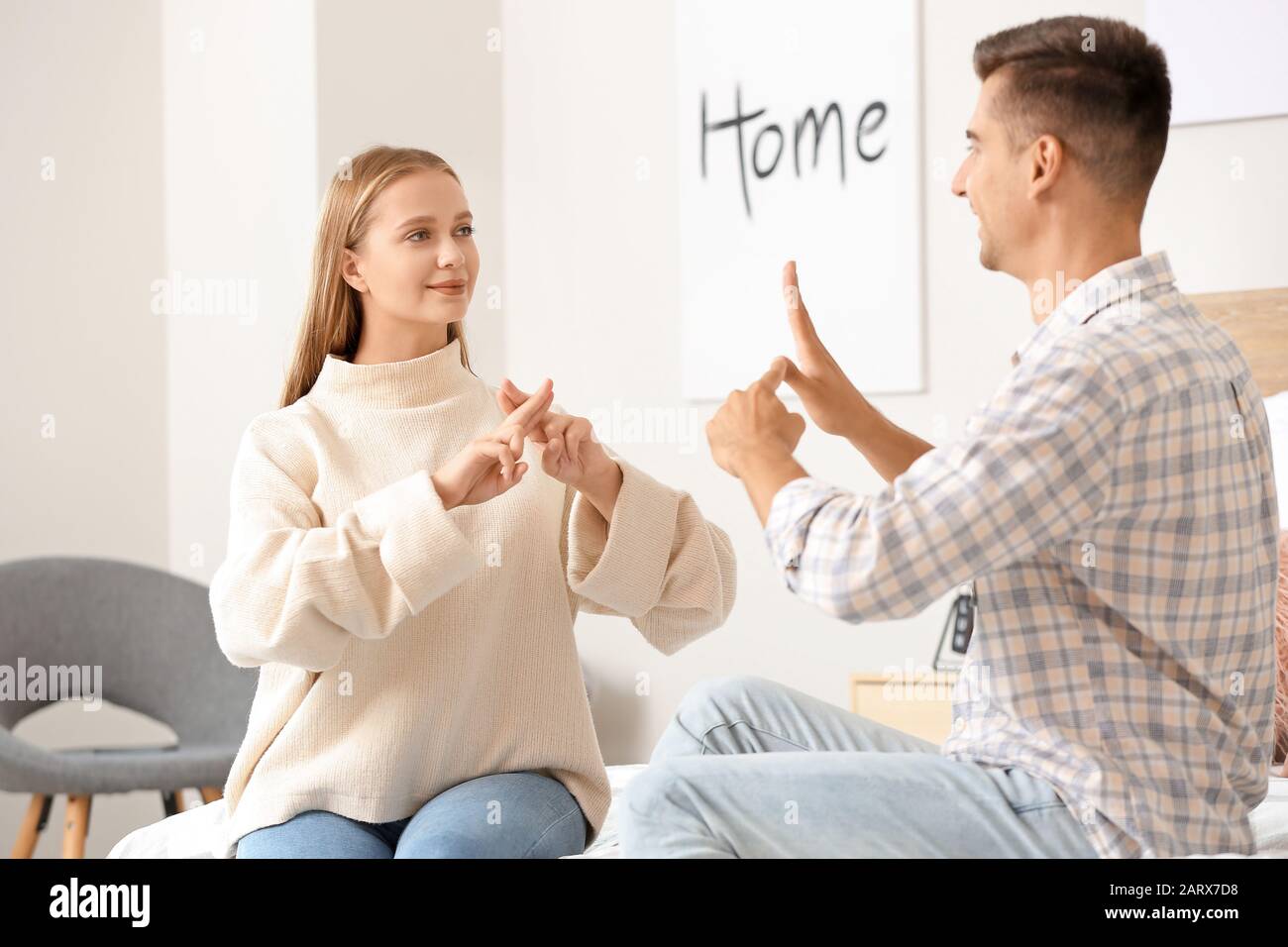 Young deaf mute couple using sign language at home Stock Photo - Alamy
