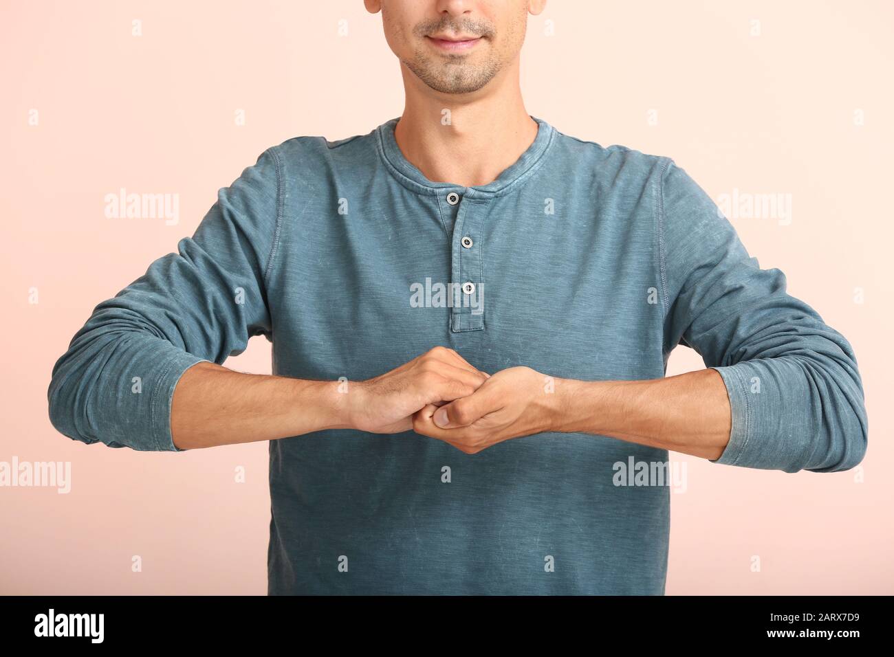 Young deaf mute man using sign language on color background Stock Photo ...