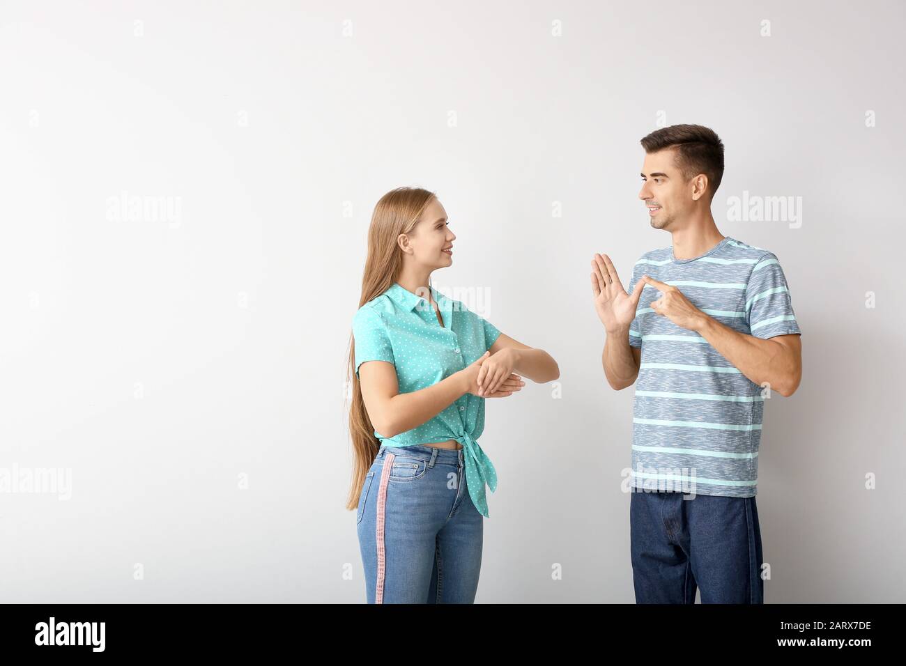 Young deaf mute couple using sign language on white background Stock ...