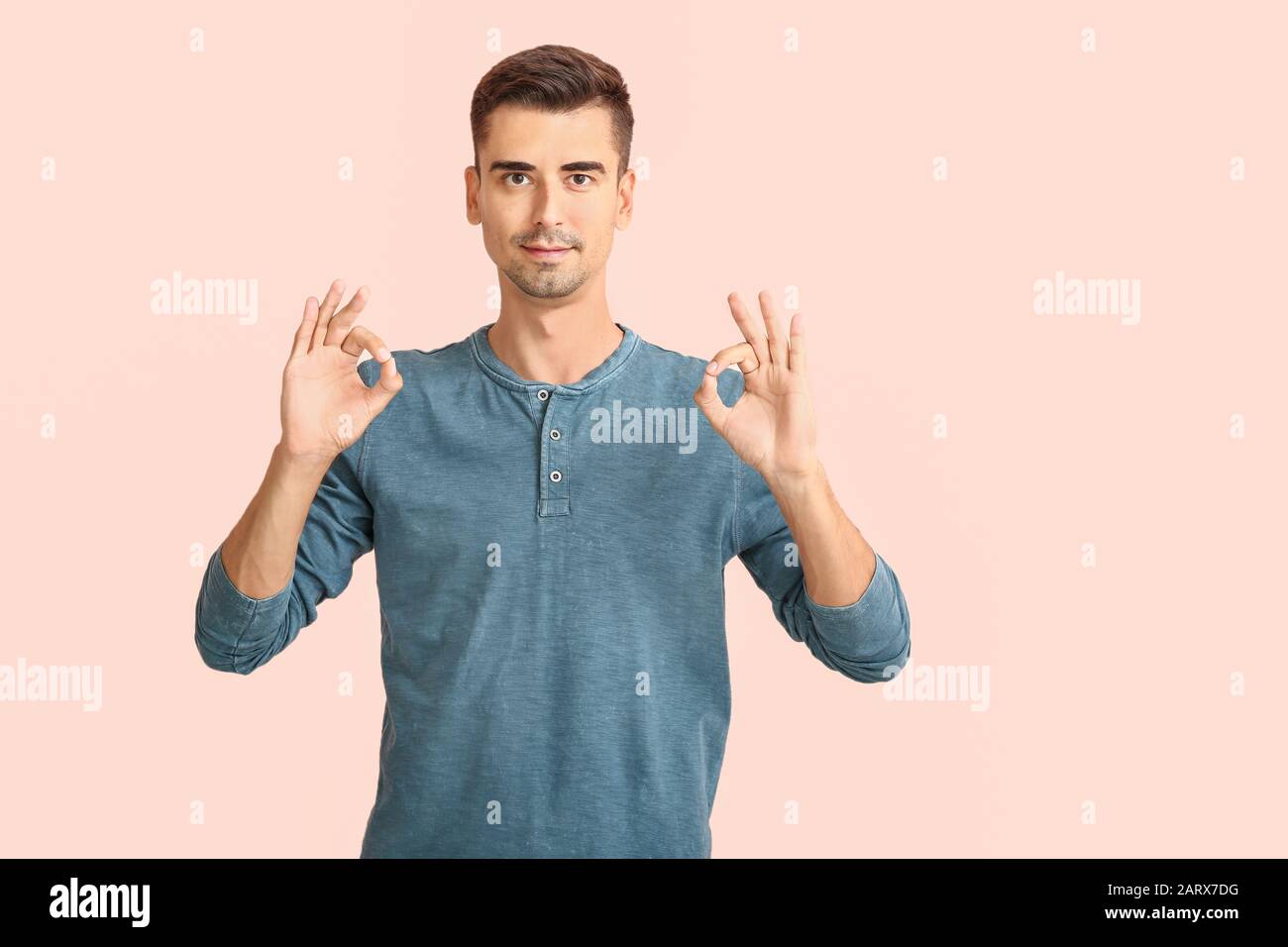Young deaf mute man using sign language on color background Stock Photo ...