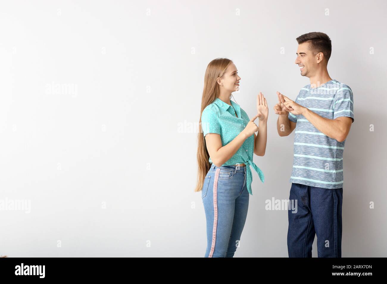 Young deaf mute couple using sign language on white background Stock ...