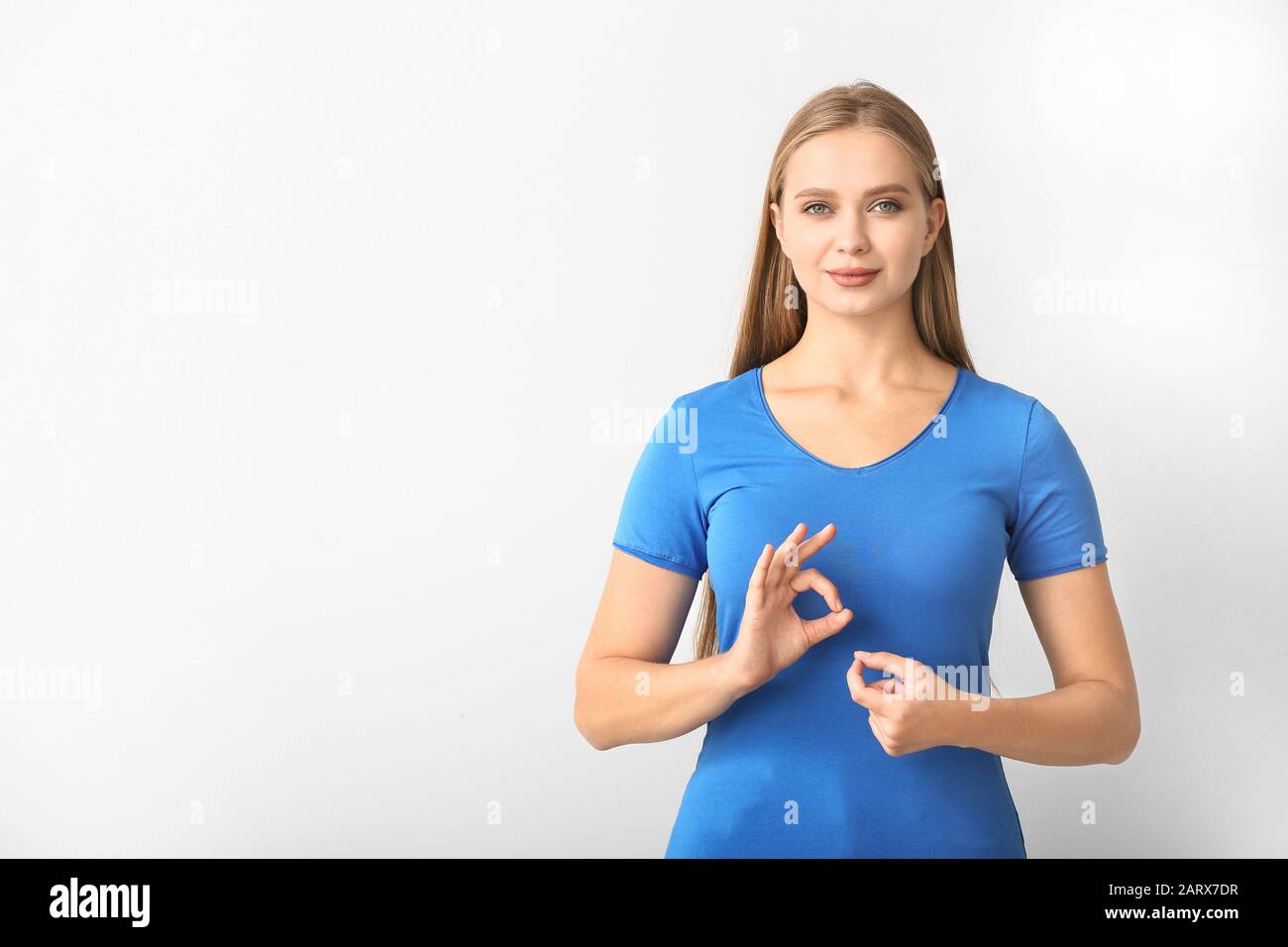 Young deaf mute woman using sign language on white background Stock ...