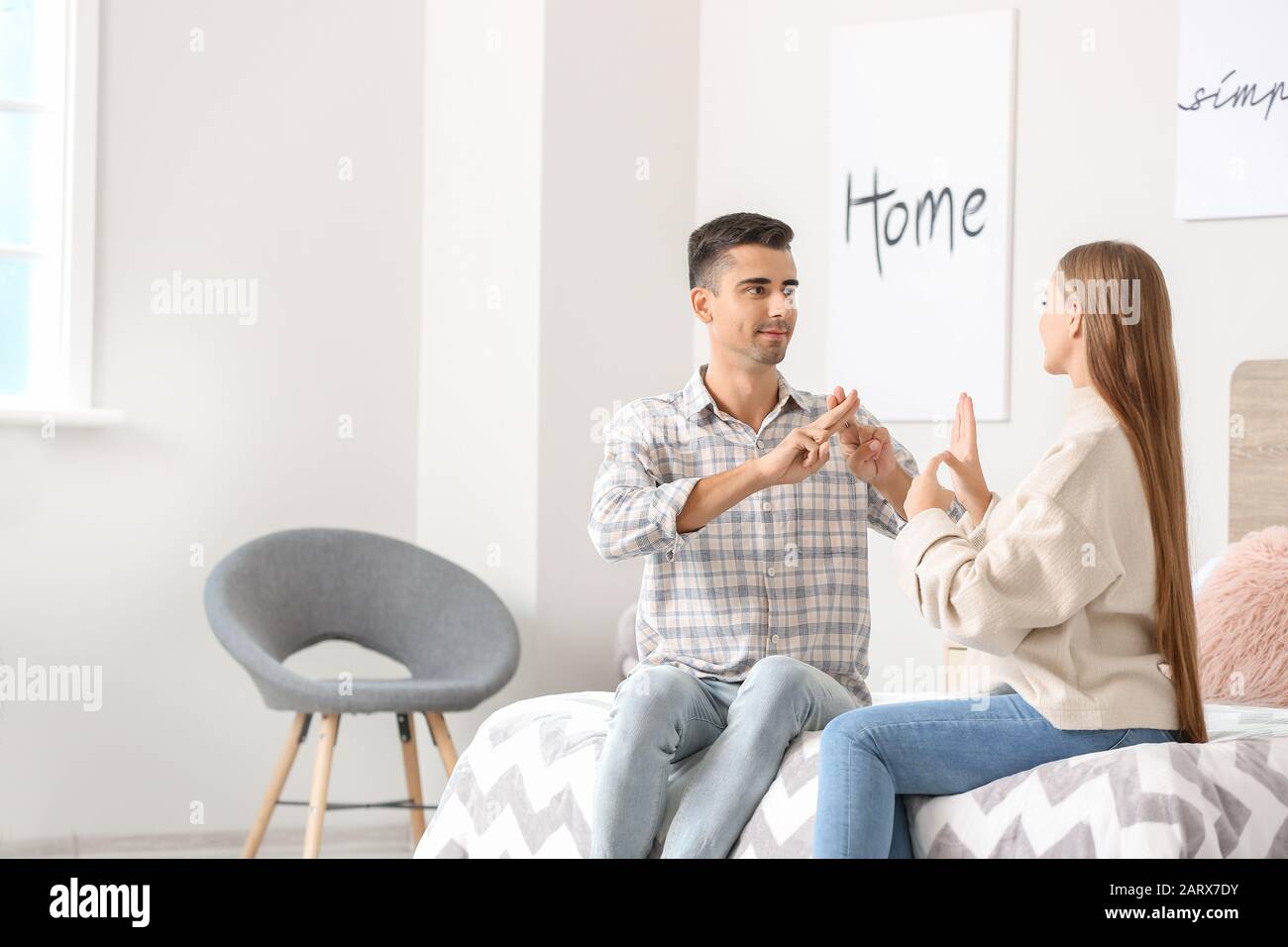 Young deaf mute couple using sign language at home Stock Photo - Alamy