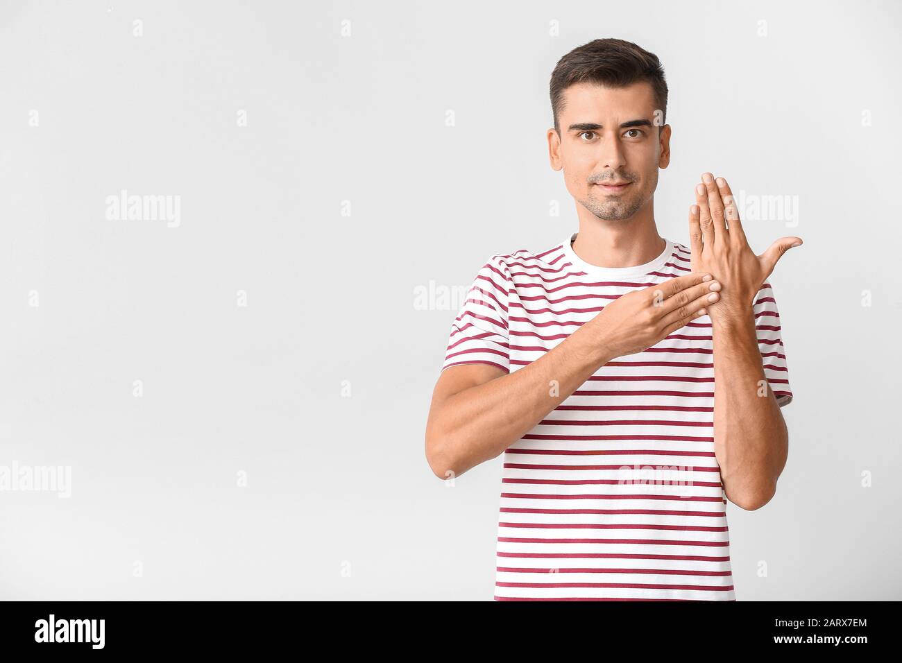 Young deaf mute man using sign language on white background Stock Photo ...