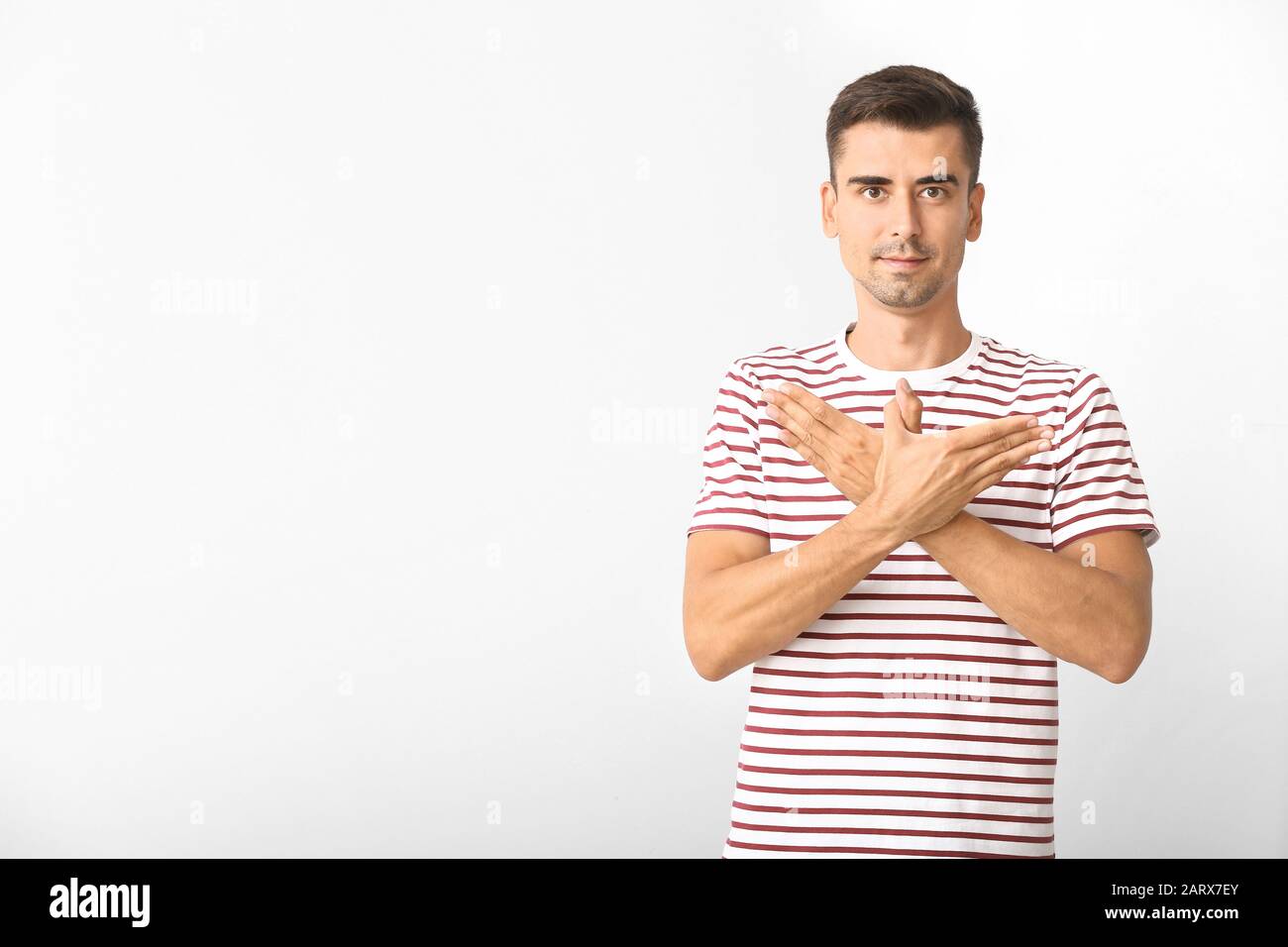 Young deaf mute man using sign language on white background Stock Photo ...