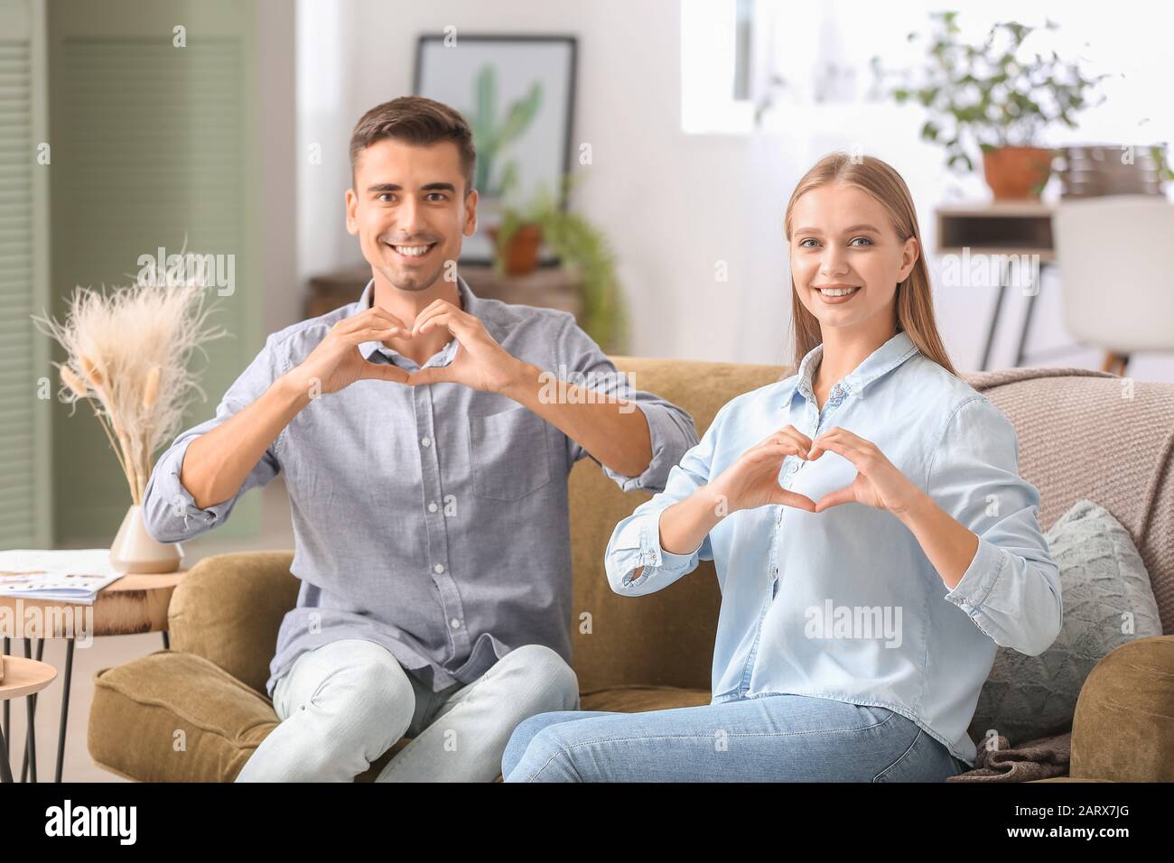 Young deaf mute couple using sign language at home Stock Photo - Alamy