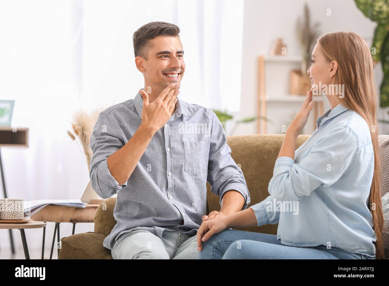 Young deaf mute couple using sign language at home Stock Photo - Alamy