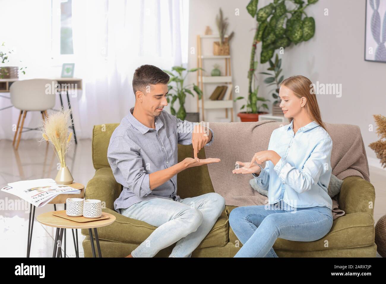 Young deaf mute couple using sign language at home Stock Photo - Alamy