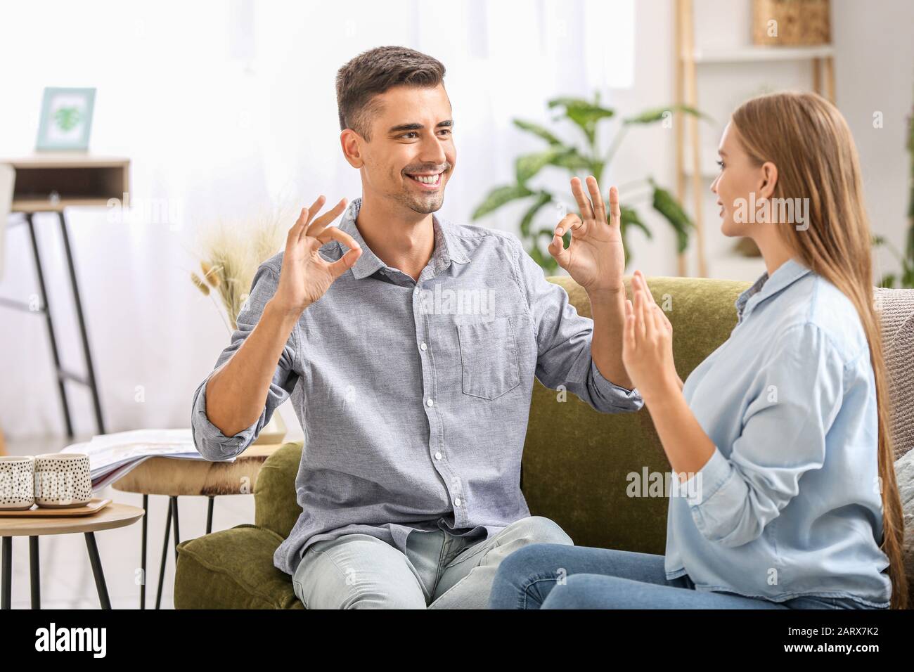 Young deaf mute couple using sign language at home Stock Photo - Alamy