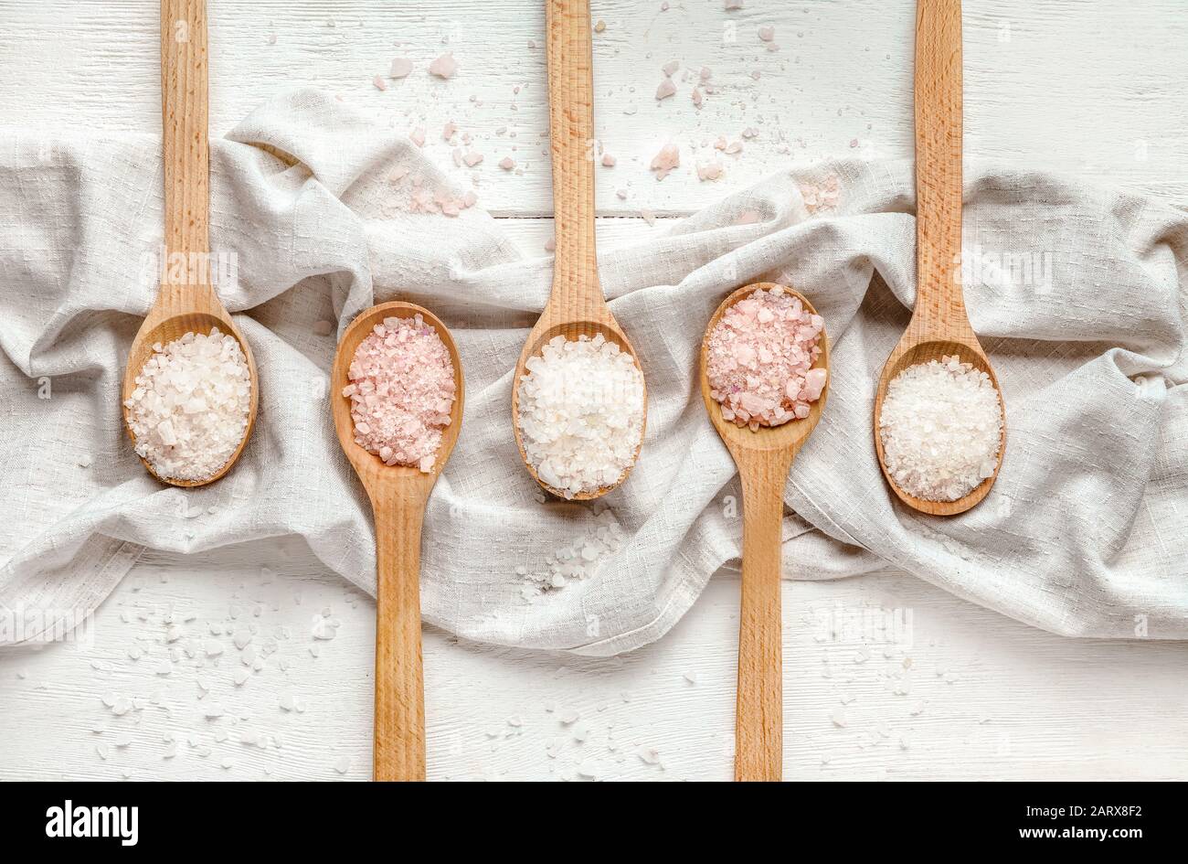 Spoons with sea salt for spa procedures on table Stock Photo - Alamy
