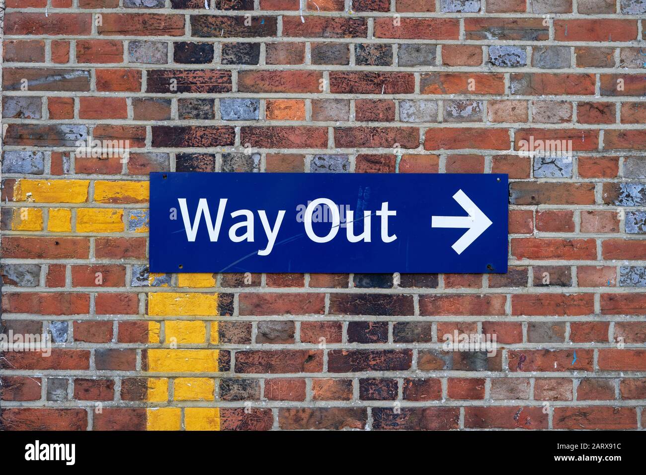A blue way out sign on a brick wall Stock Photo - Alamy