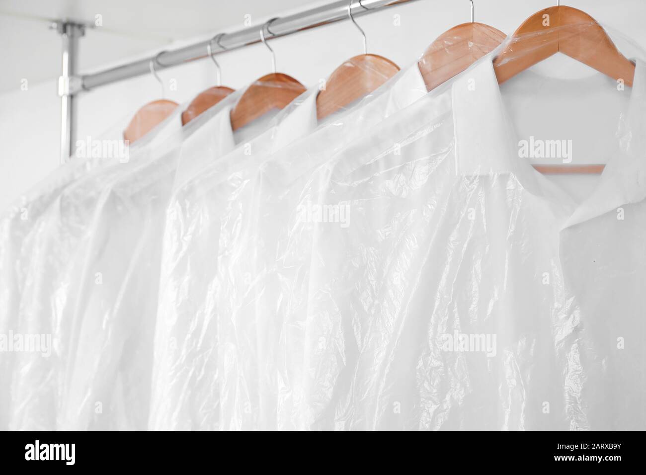 Rack with clothes in modern dry-cleaner's, closeup Stock Photo - Alamy