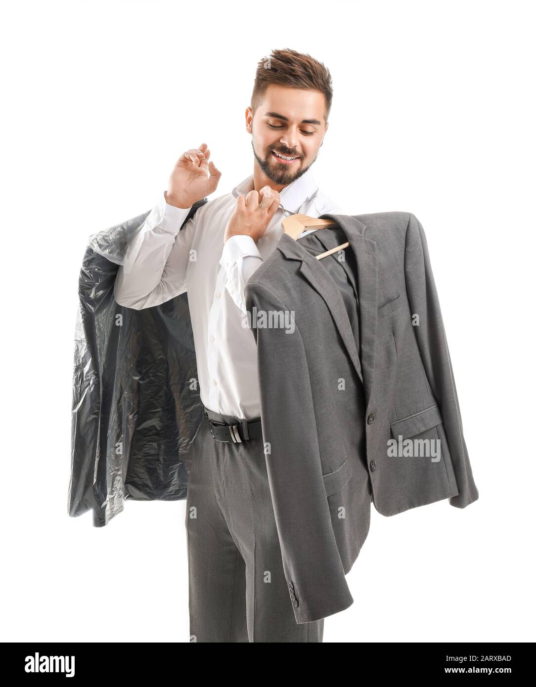 Male worker of modern dry-cleaner with clothes on white background ...