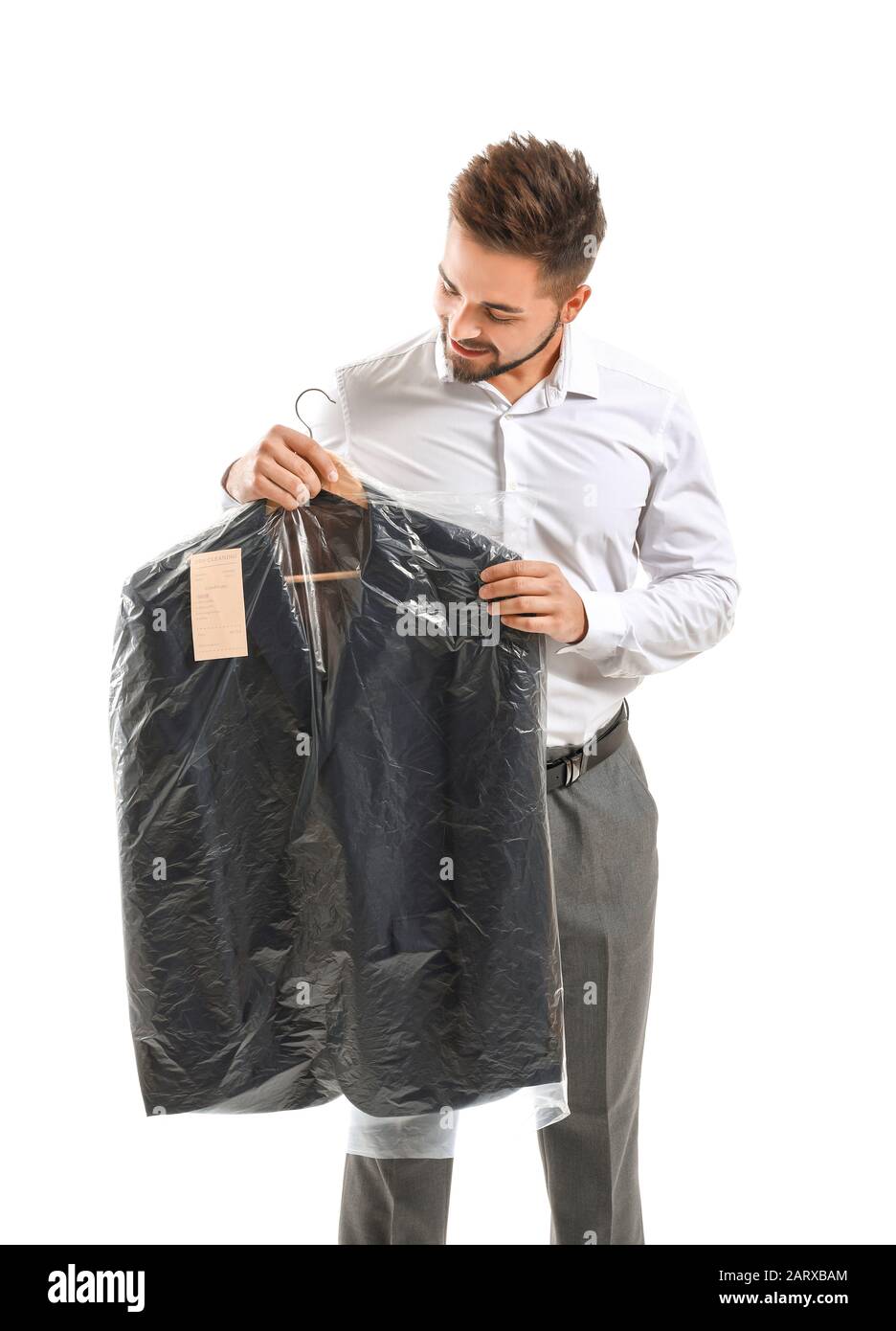 Male worker of modern dry-cleaner with clothes on white background ...