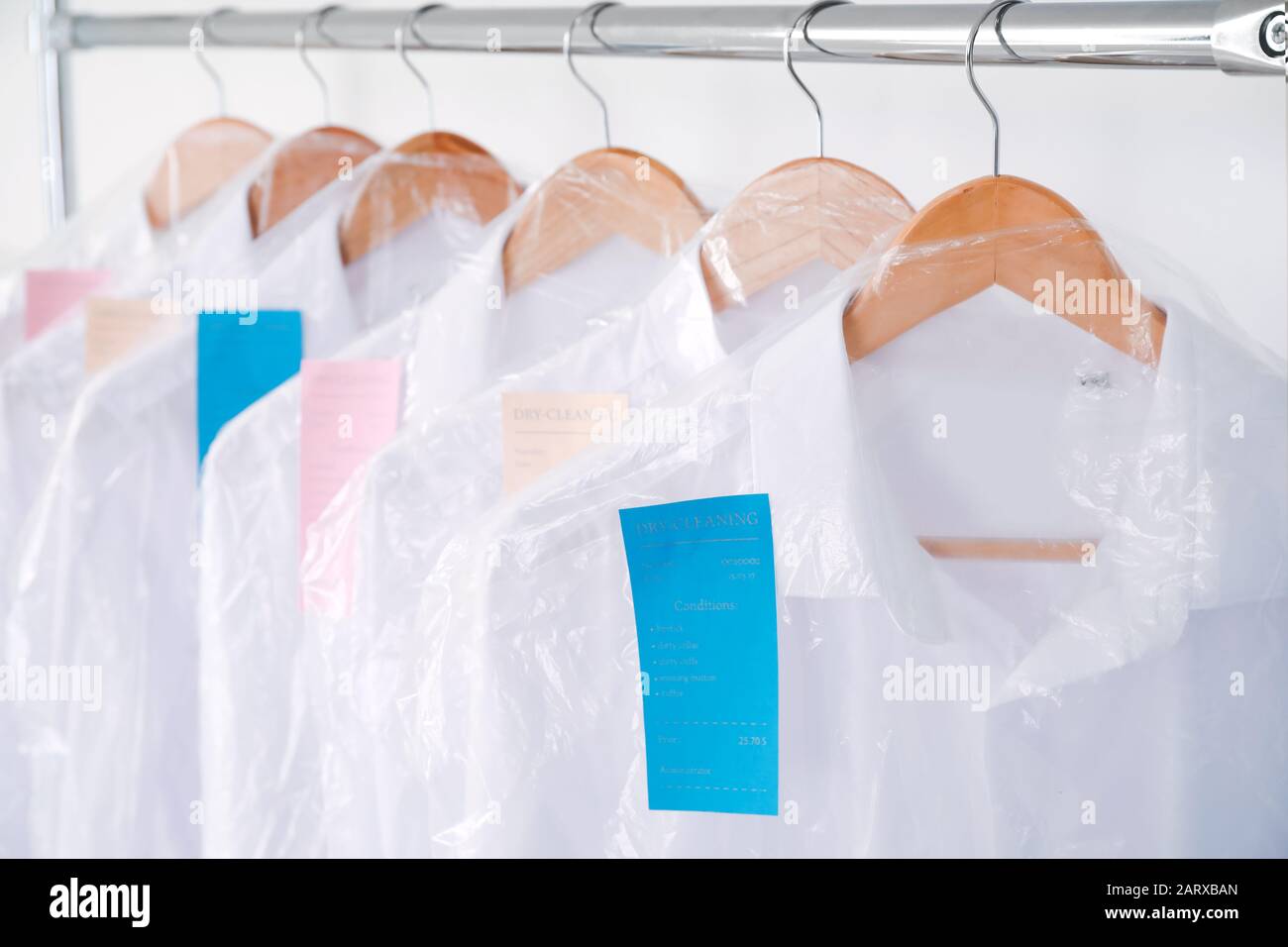 Rack with clothes in modern dry-cleaner's, closeup Stock Photo - Alamy