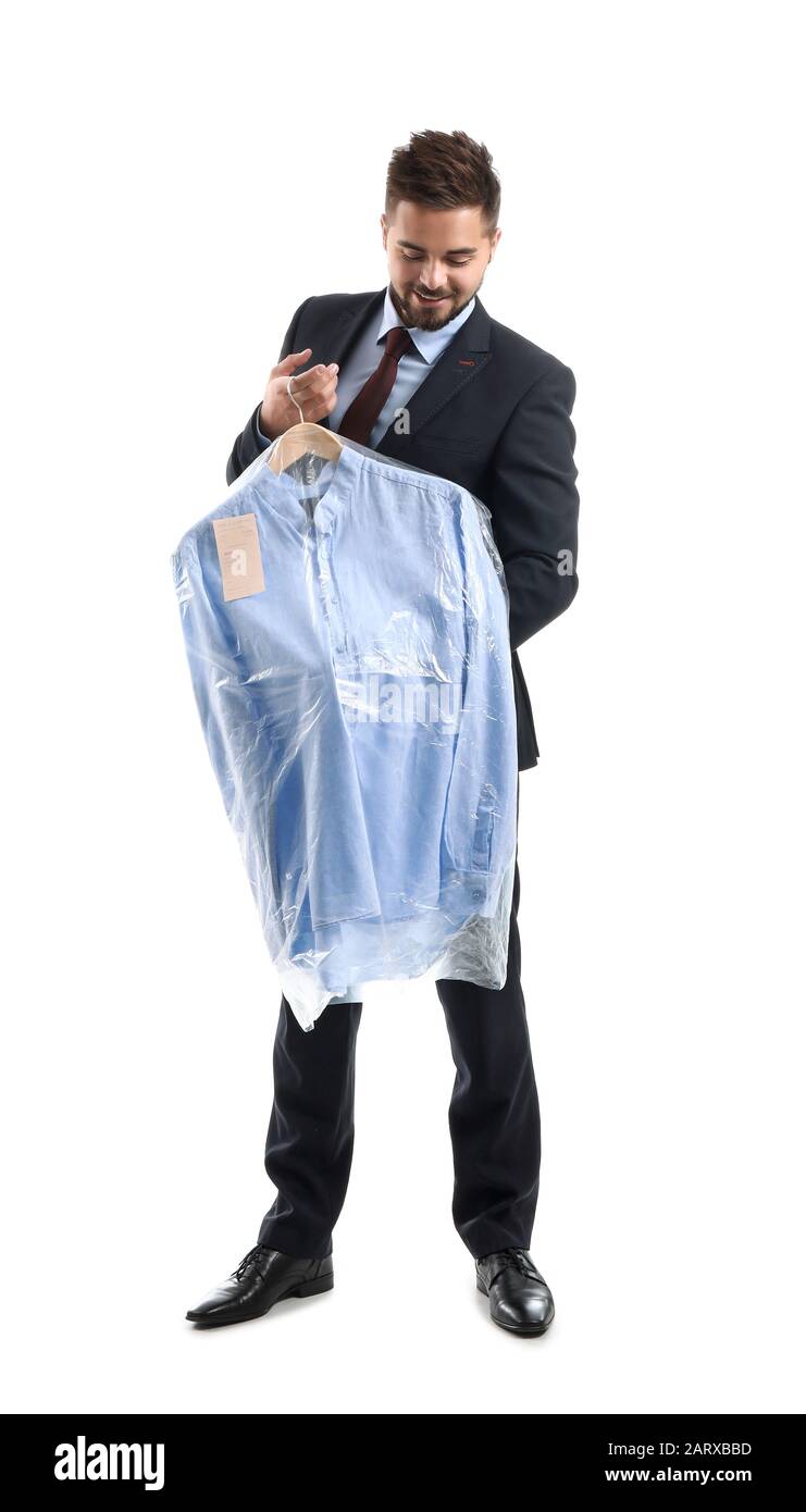 Male worker of modern dry-cleaner with clothes on white background ...