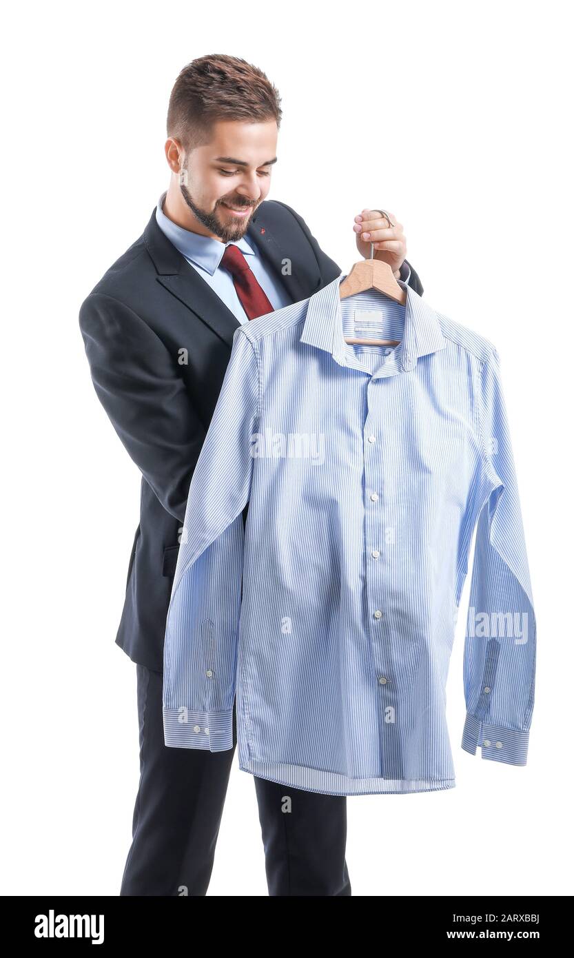 Male worker of modern dry-cleaner with clothes on white background ...