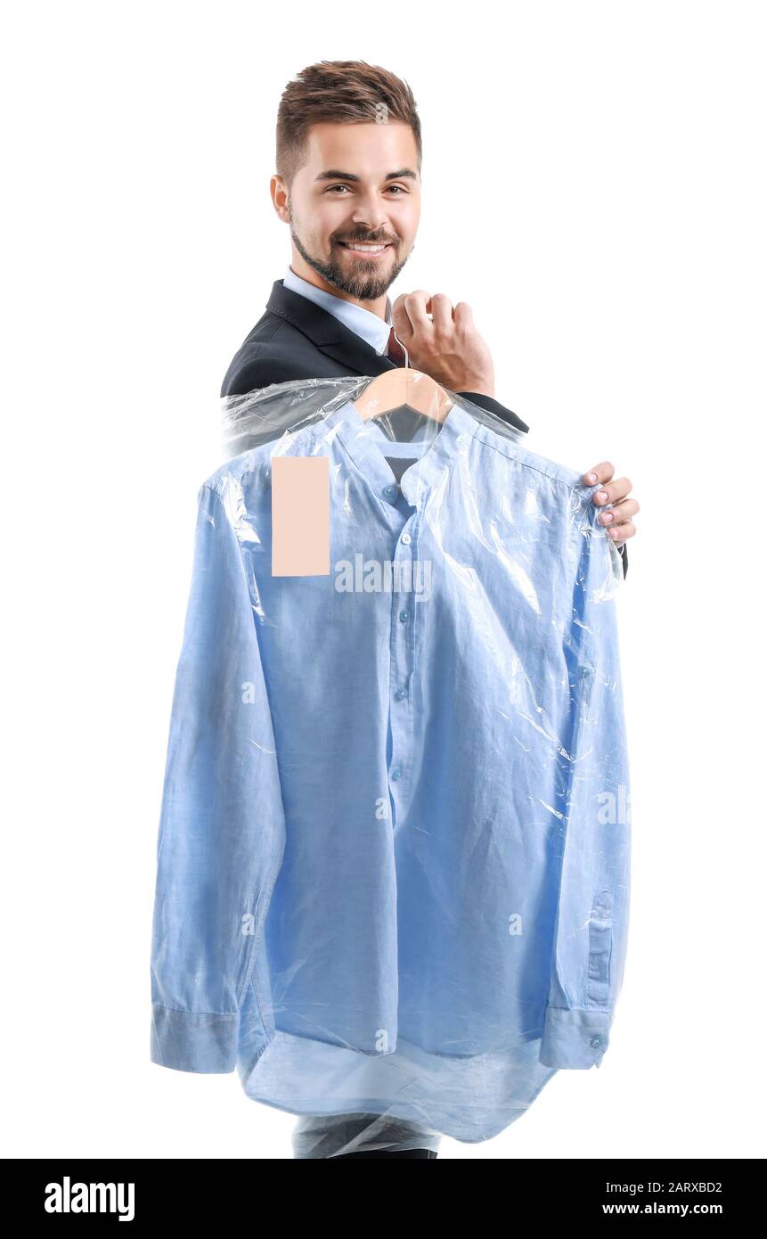 Male worker of modern dry-cleaner with clothes on white background ...