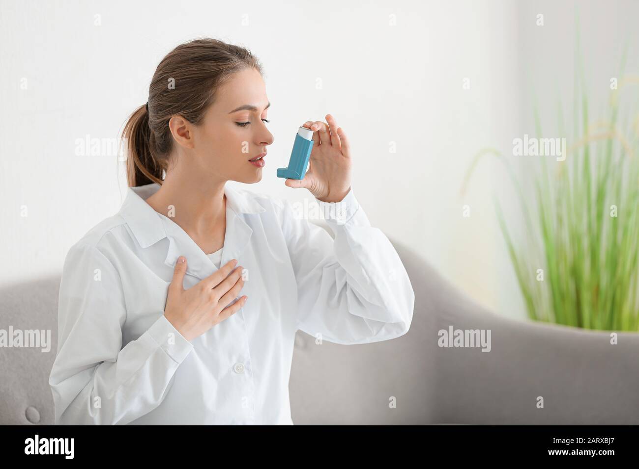 Female doctor with inhaler having asthma attack in clinic Stock Photo ...