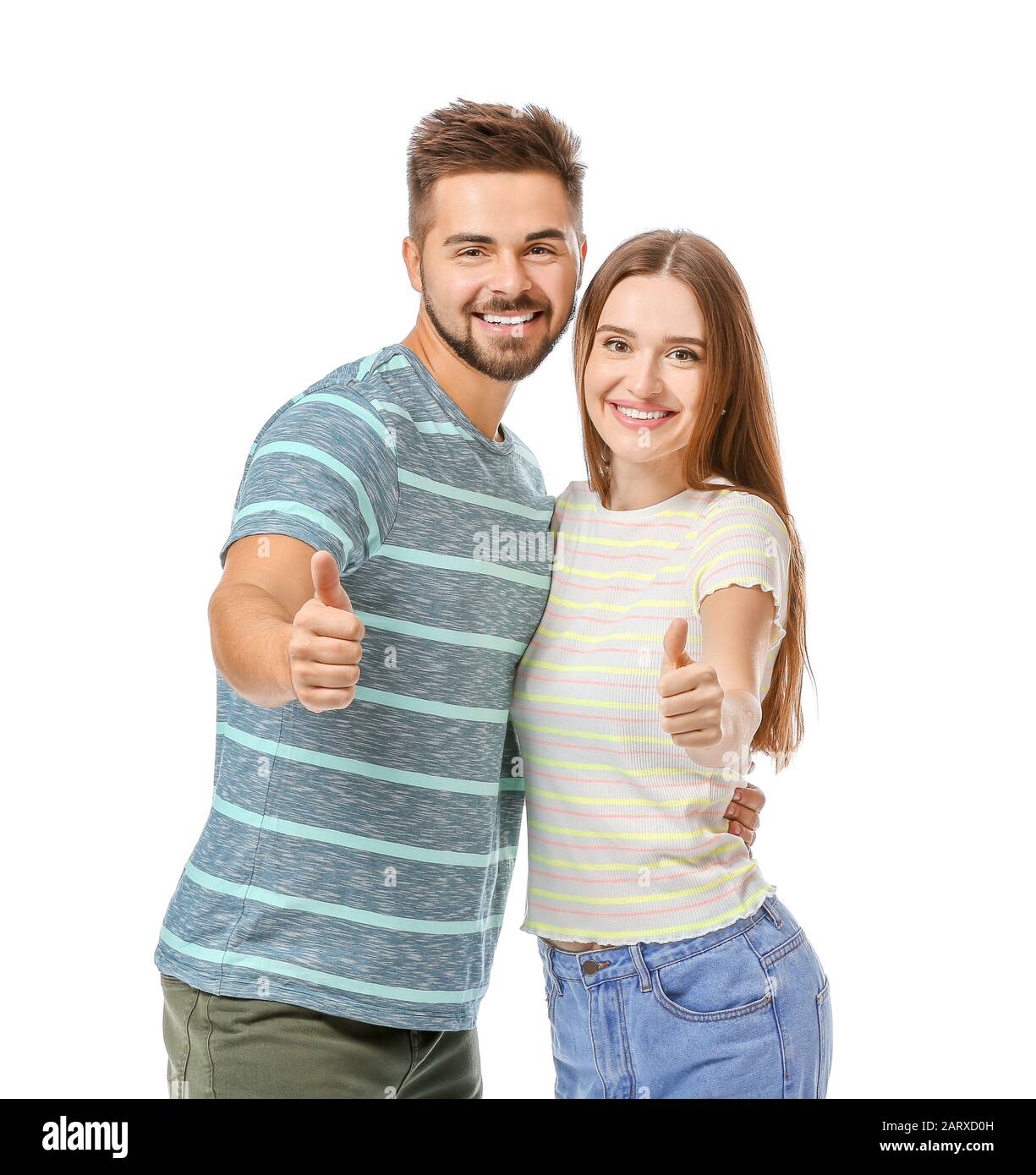Portrait of happy young couple showing thumb-up gesture on white ...