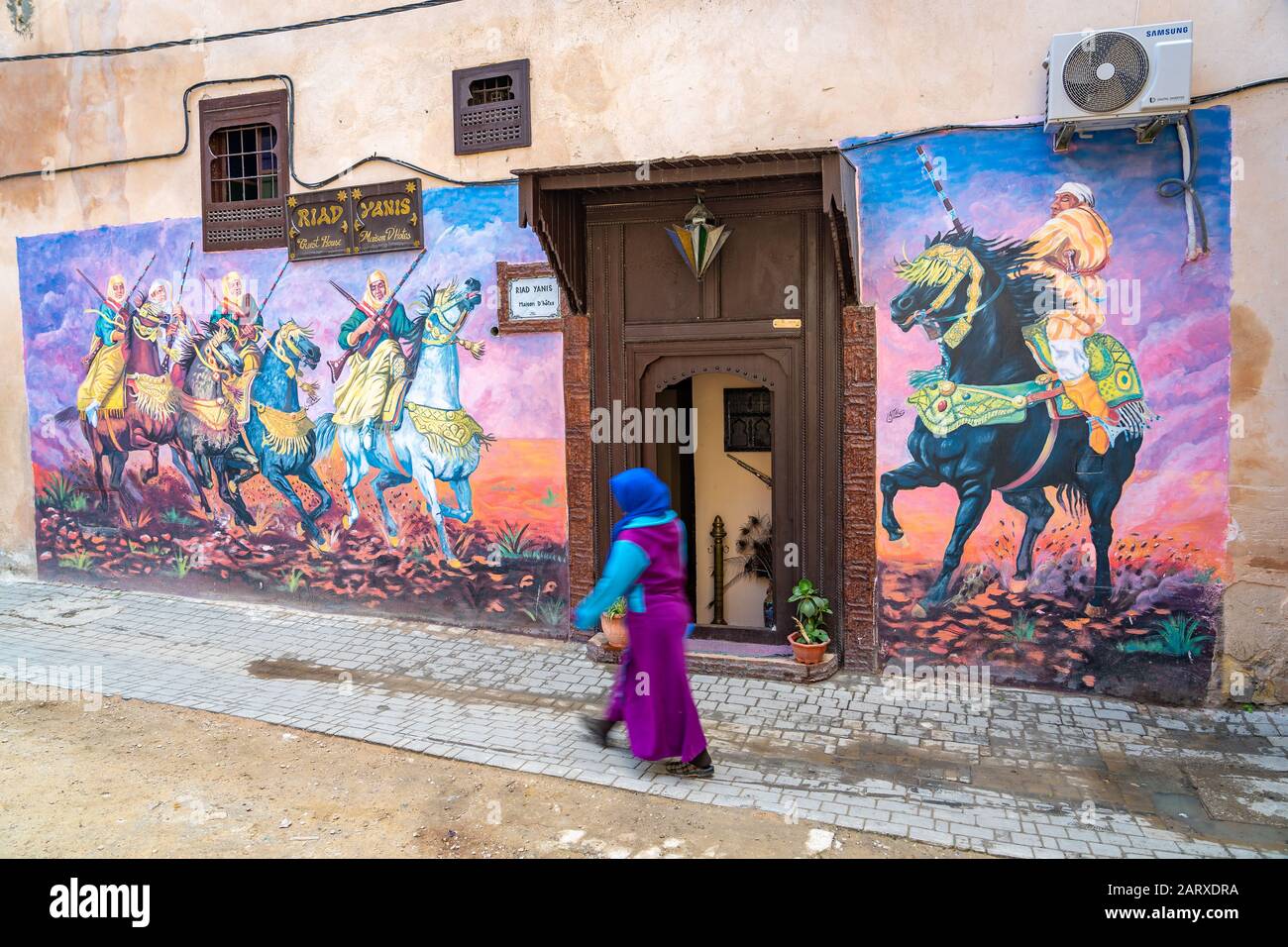 Meknes, Morocco - Woman walking park a colorful wall painting in the ...