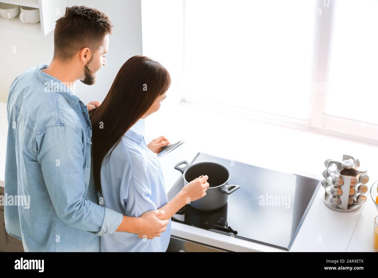 Beautiful young couple cooking together in kitchen at home Stock Photo ...