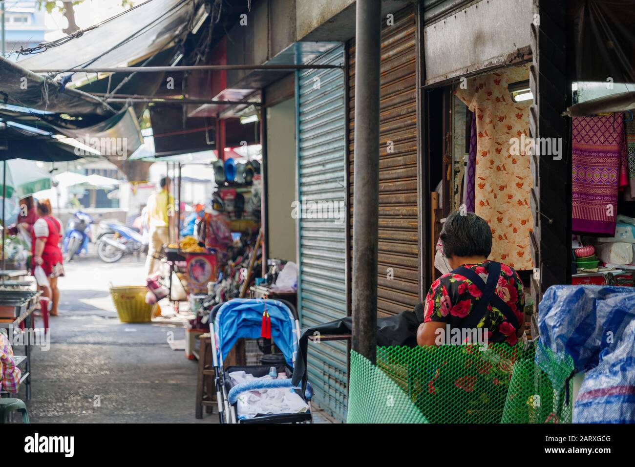 Woman sit in front of tailor shop inside old mess stall with some ...