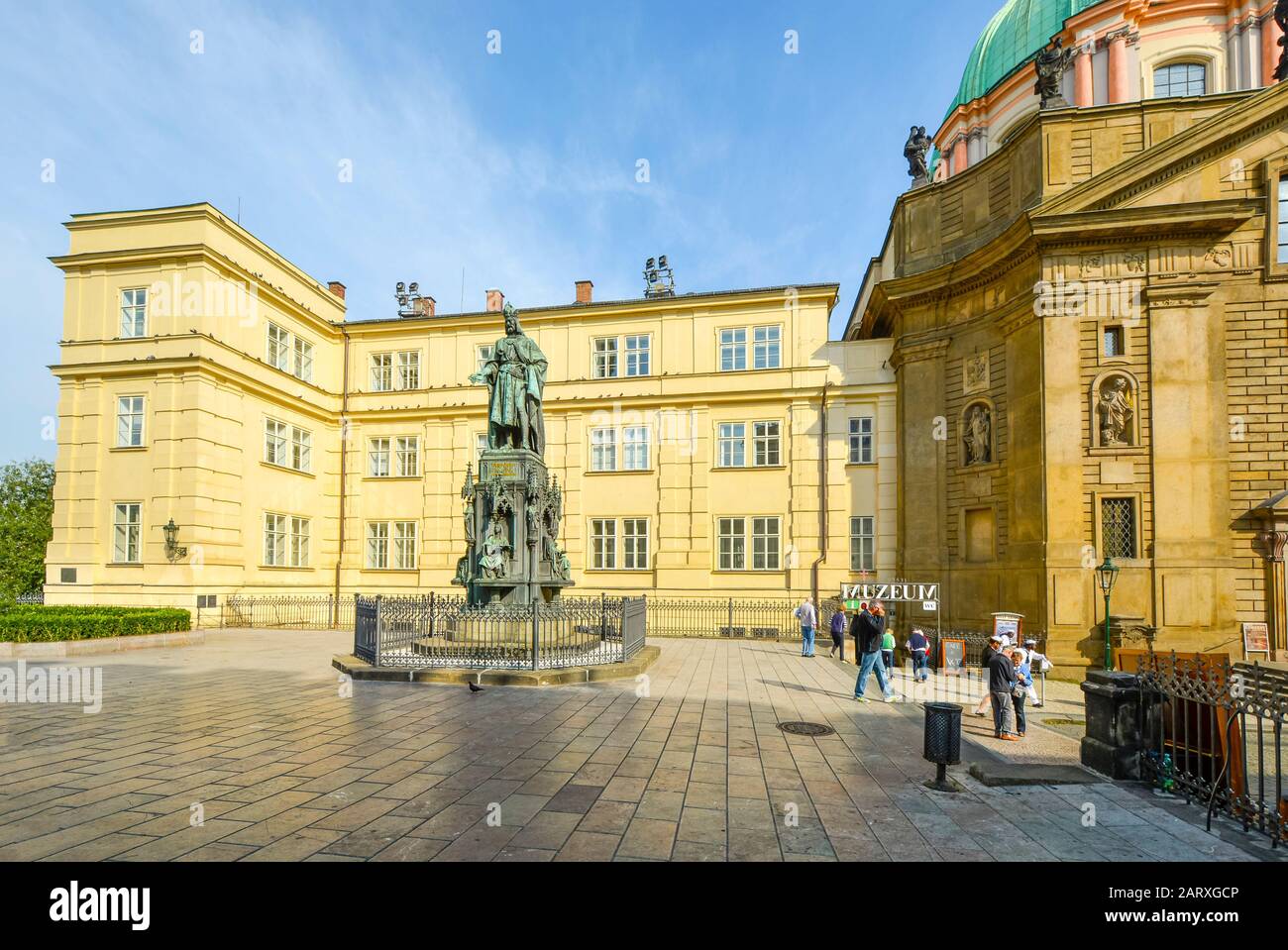 Tourists enter the Charles Bridge Museum near the statue of Charles IV ...